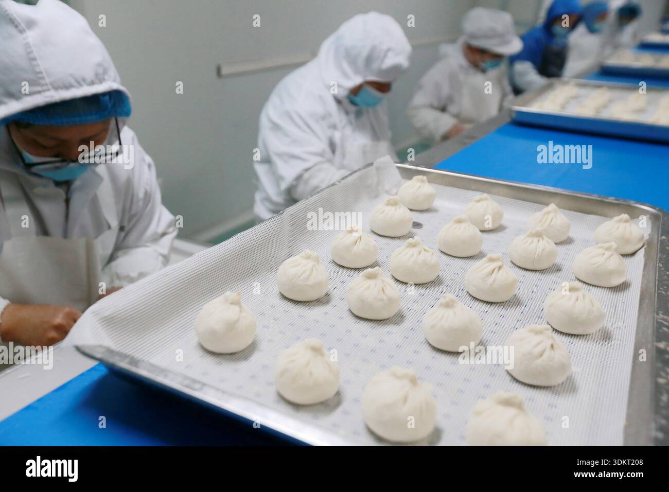 Workers make buns at a bun production enterprise in Henggou Village ...