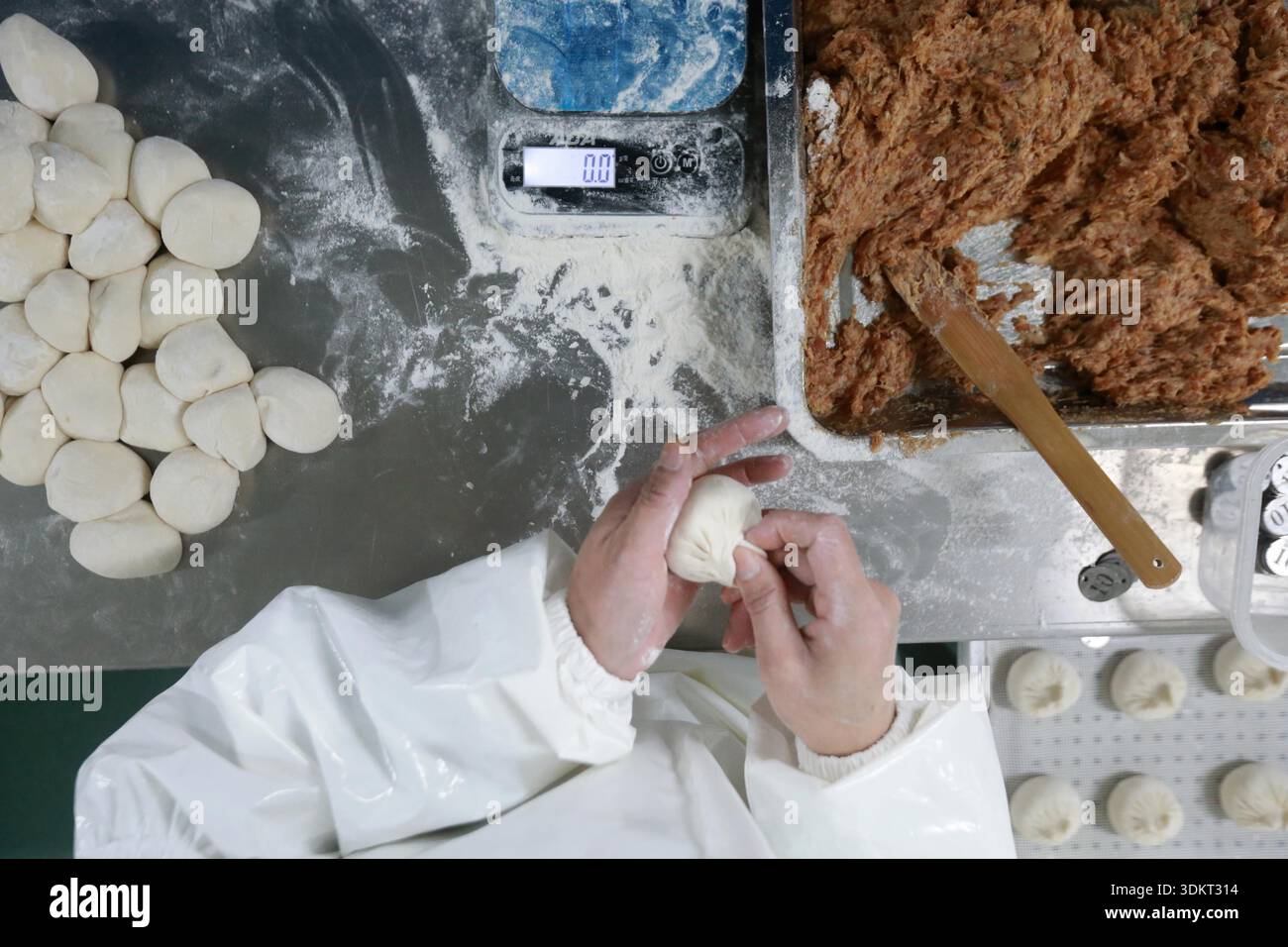 Workers make buns at a bun production enterprise in Henggou Village ...