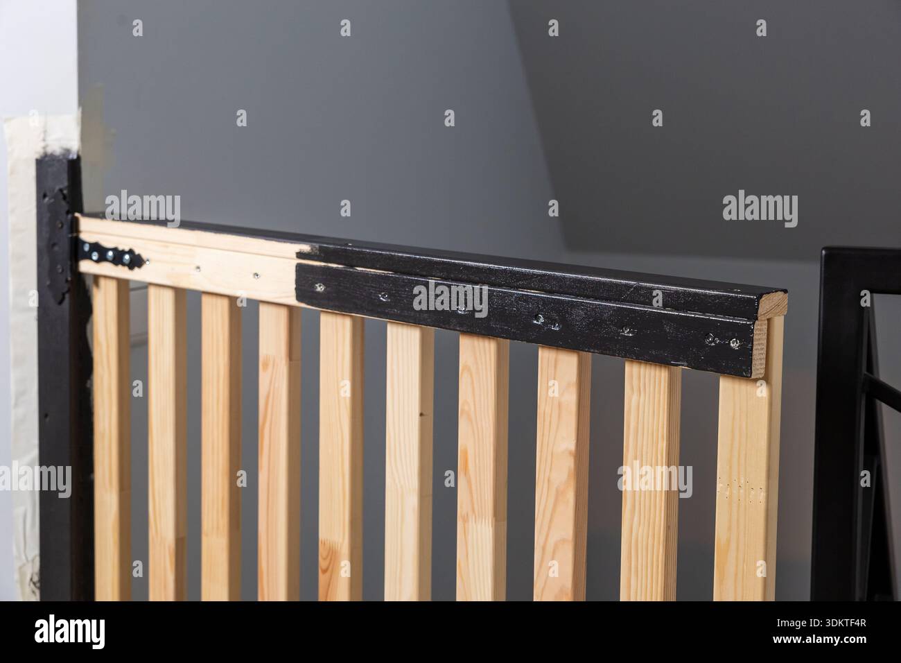 Indoor wooden safety gate with vertical slats and black metal hardware ...