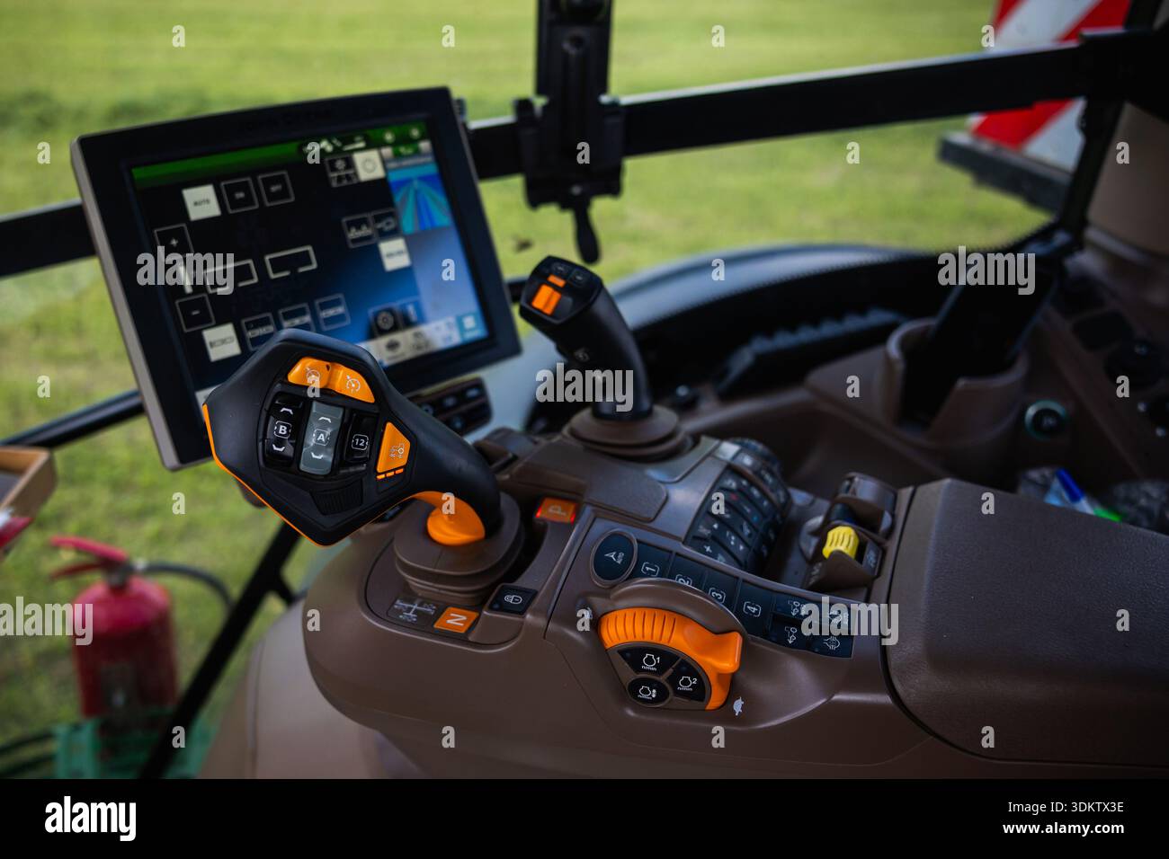 Close up of a modern tractor cockpit shows a touchscreen guidance ...