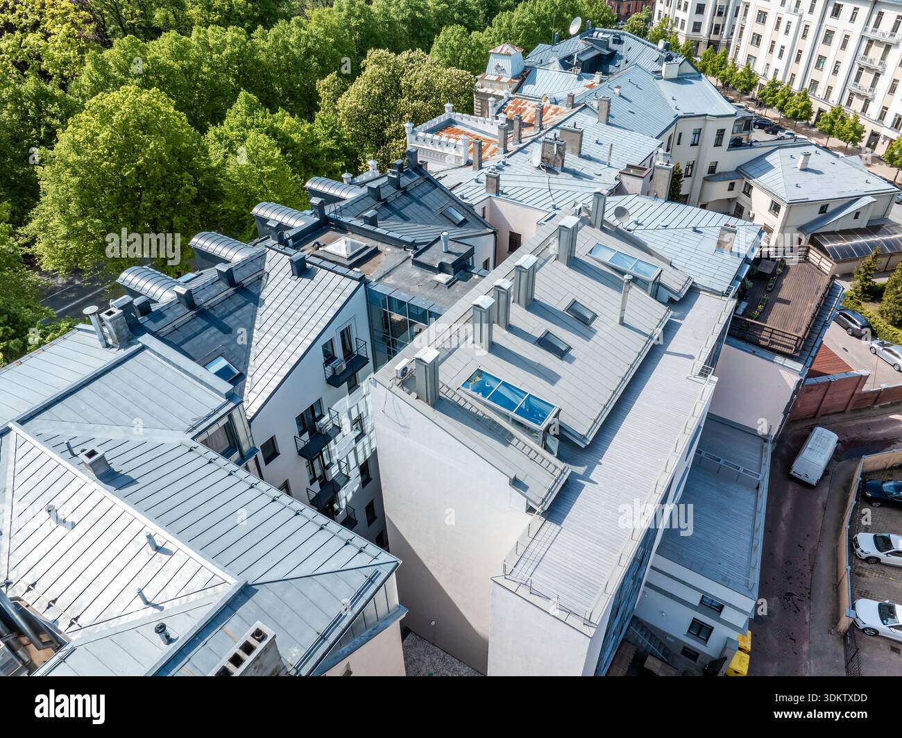Cluster of modern buildings with light facades, metal roofs, and ...