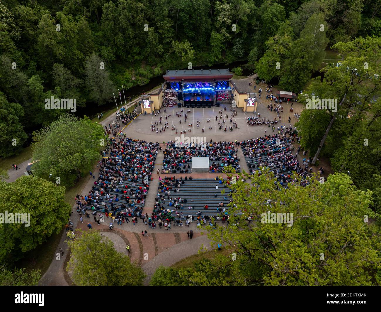 An aerial view of an outdoor amphitheater surrounded by tall trees ...