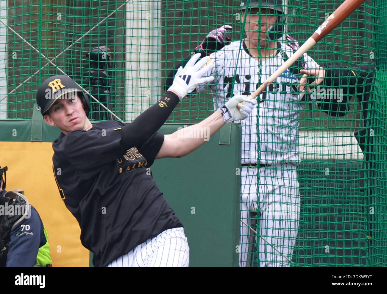 Hanshin Tigers infielder Cam Devanney swings during the 2026 Spring ...