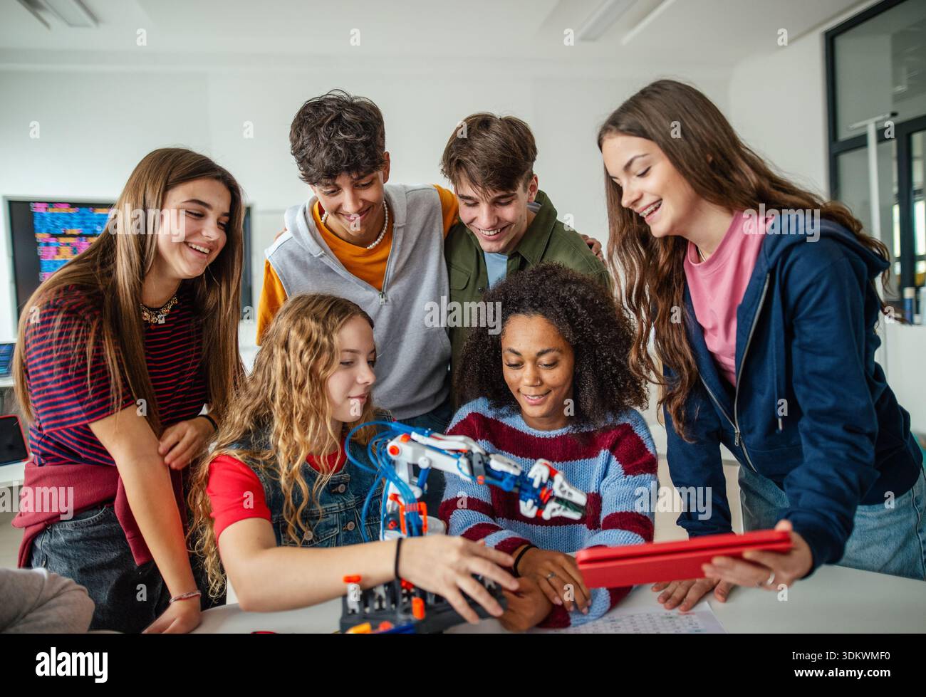 Group of high school students building robotic arm in STEM classroom ...