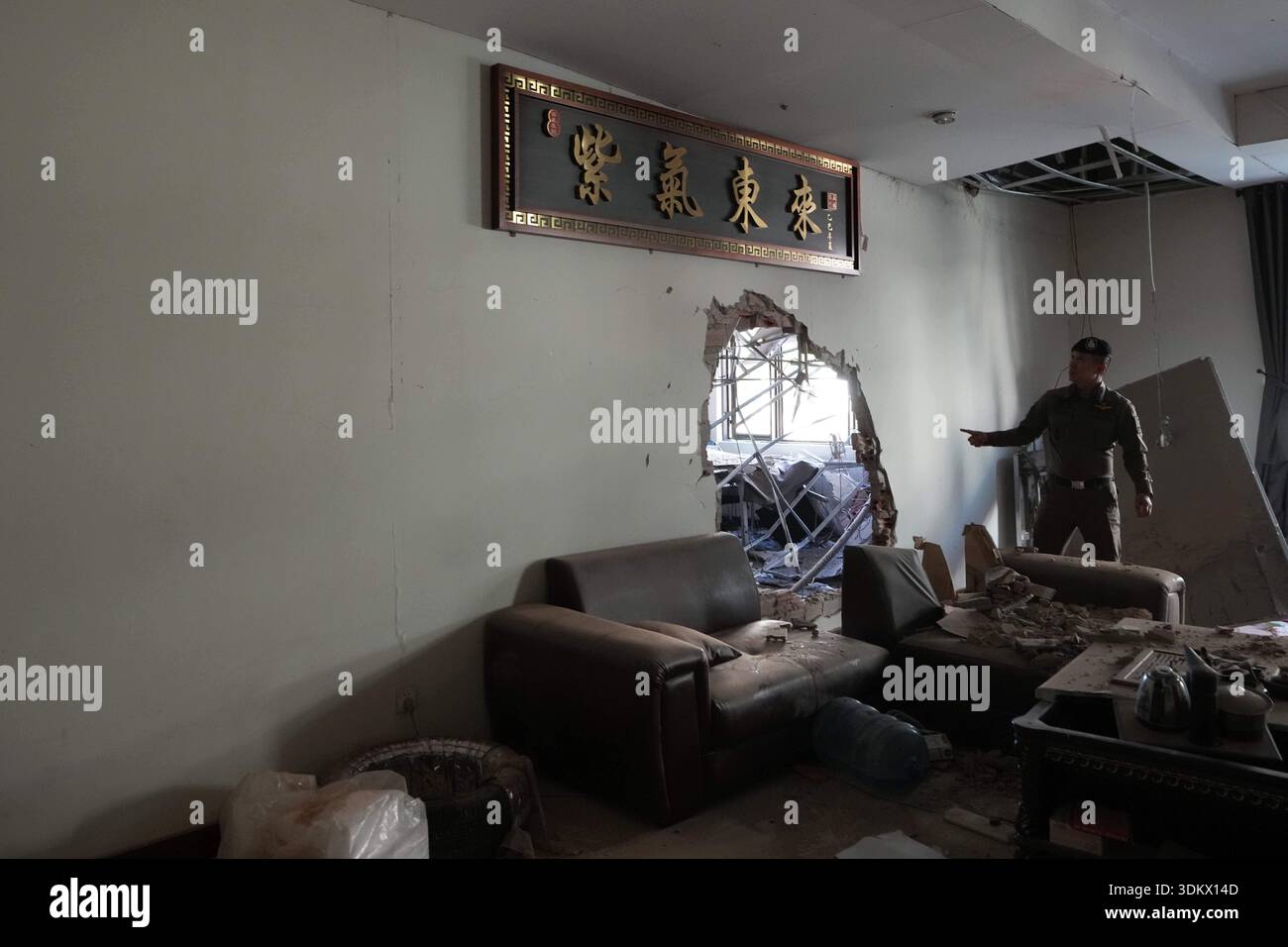 A Thai policeman inspects a scam compound in O'Smach, Cambodia, Monday ...