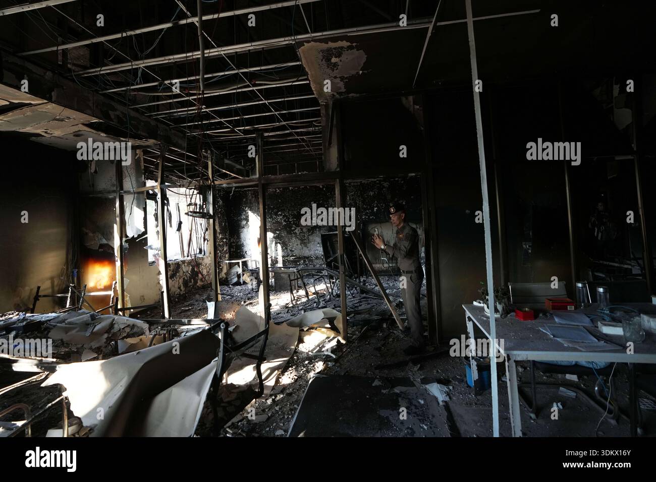 A Thai policeman inspects a damaged work station at a scam compound in ...