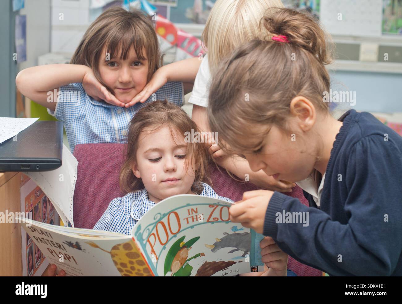 Primary school age children reading with their teacher Stock Photo - Alamy