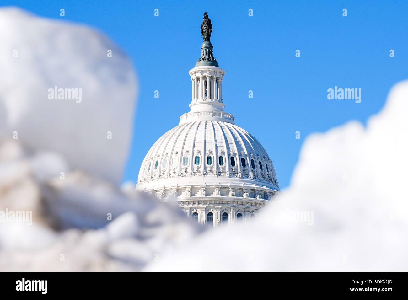 The U.S. Capitol is photographed behind the piled snow and ice debris ...