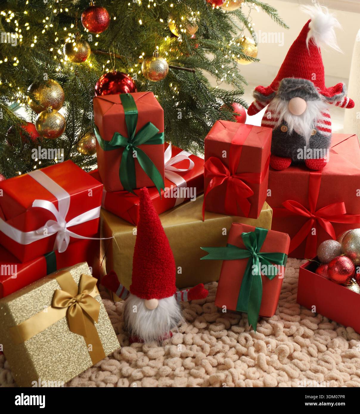 Beautiful wrapped gifts and decorative gnomes under Christmas tree at ...