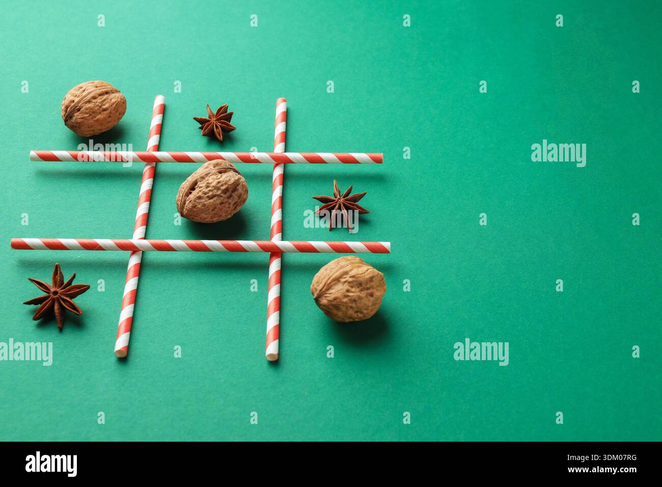 Tic tac toe game made with walnuts and anise stars on green background ...