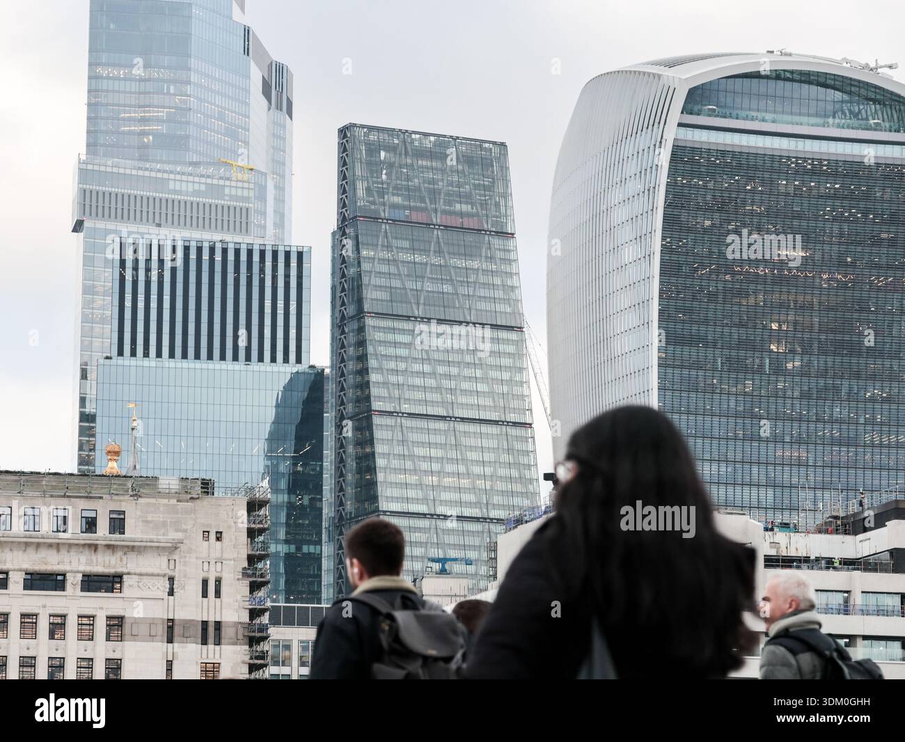 People walk on London Bridge in front of City of London skyscrapers ...