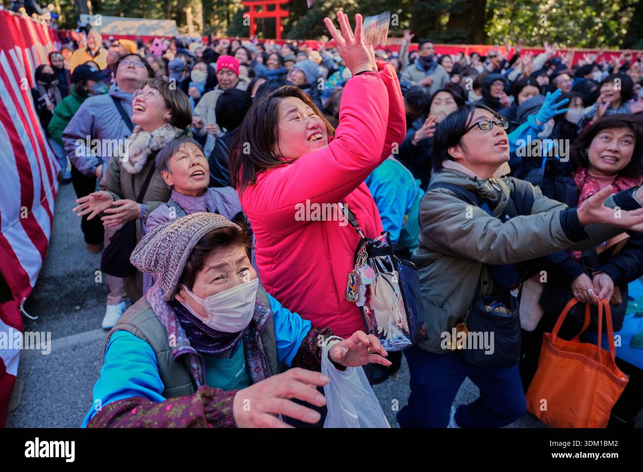 People try to catch lucky beans during the annual Bean Throwing ...