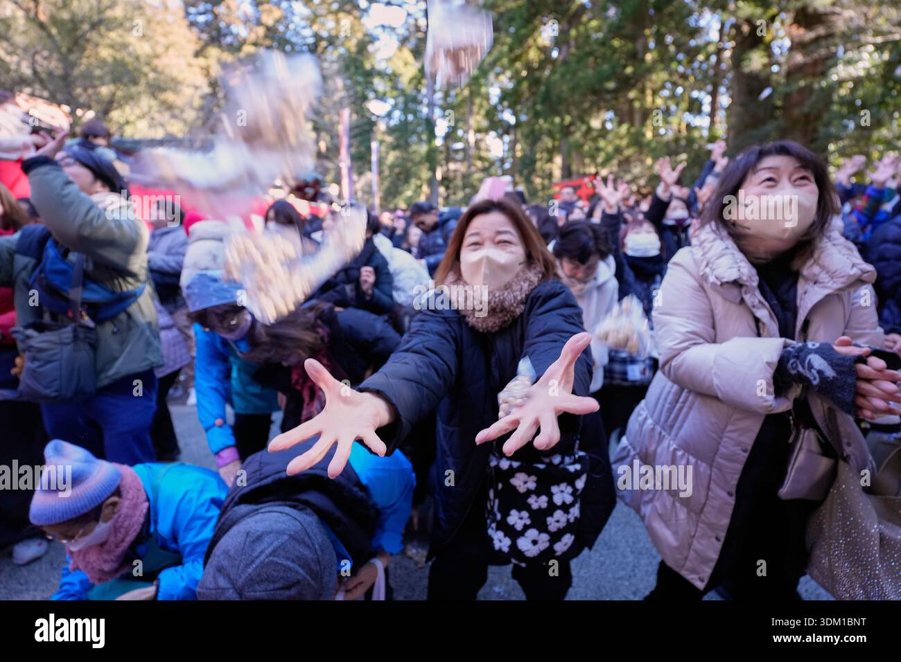 People try to catch lucky beans during the annual Bean Throwing ...