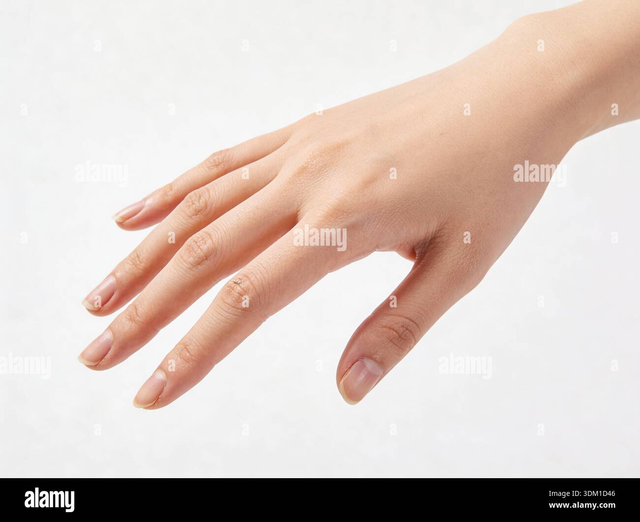 A hand with a white background. The hand is long and slender. The nails ...