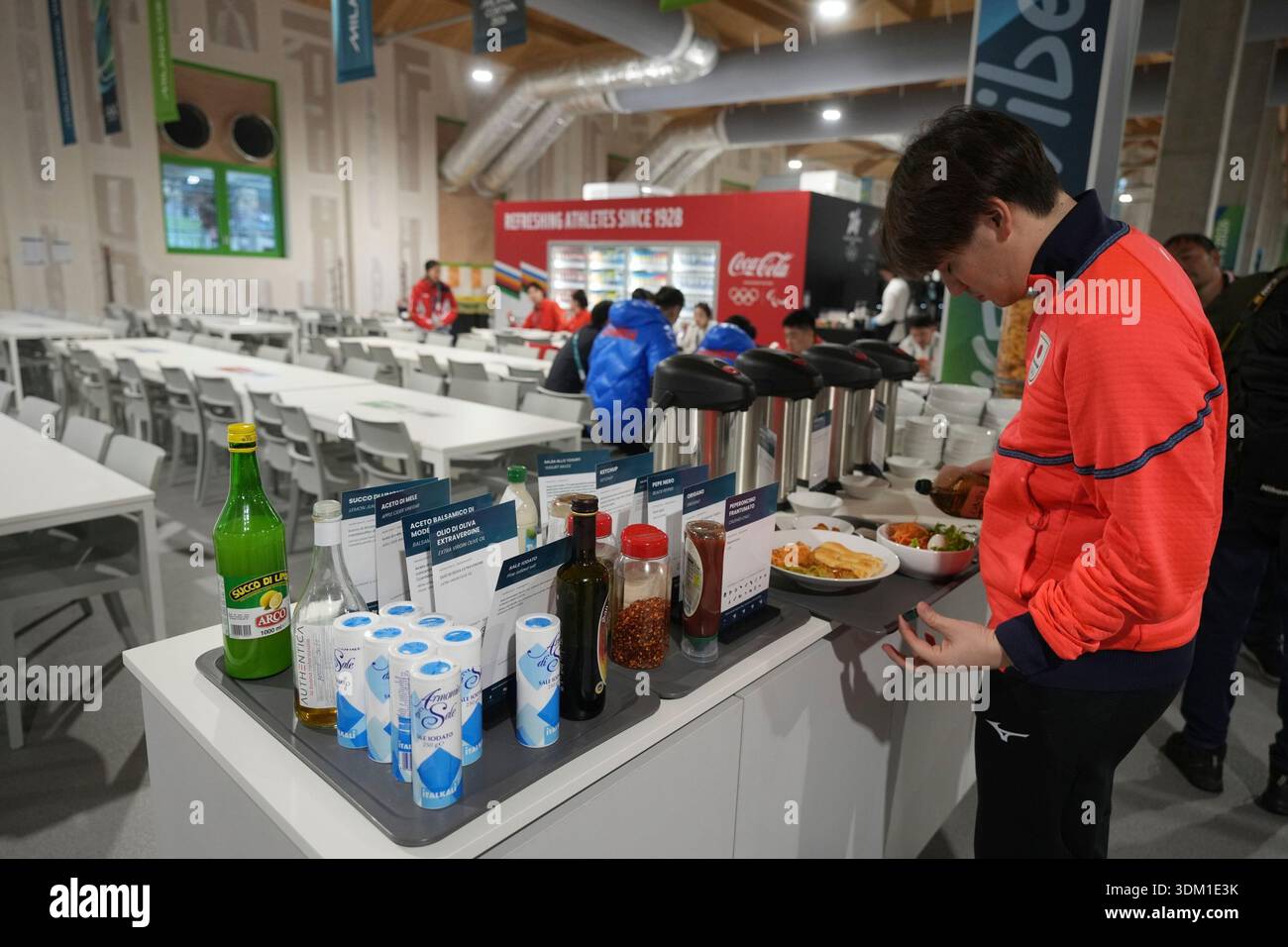 An athlete from Japan selects breakfast items at the dining hall inside ...
