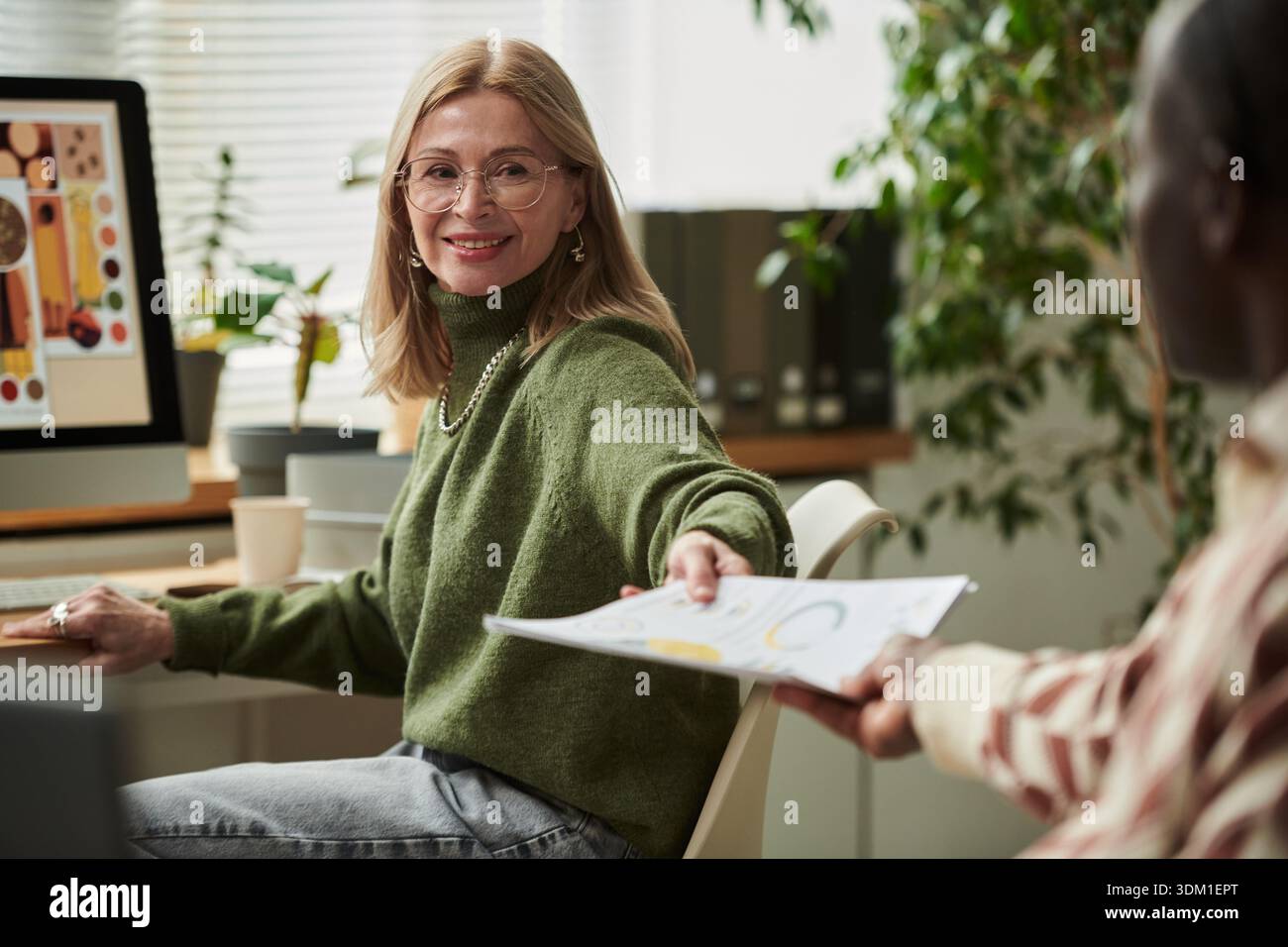 Adult Woman Smiling While Handing Document to Black Man Stock Photo - Alamy