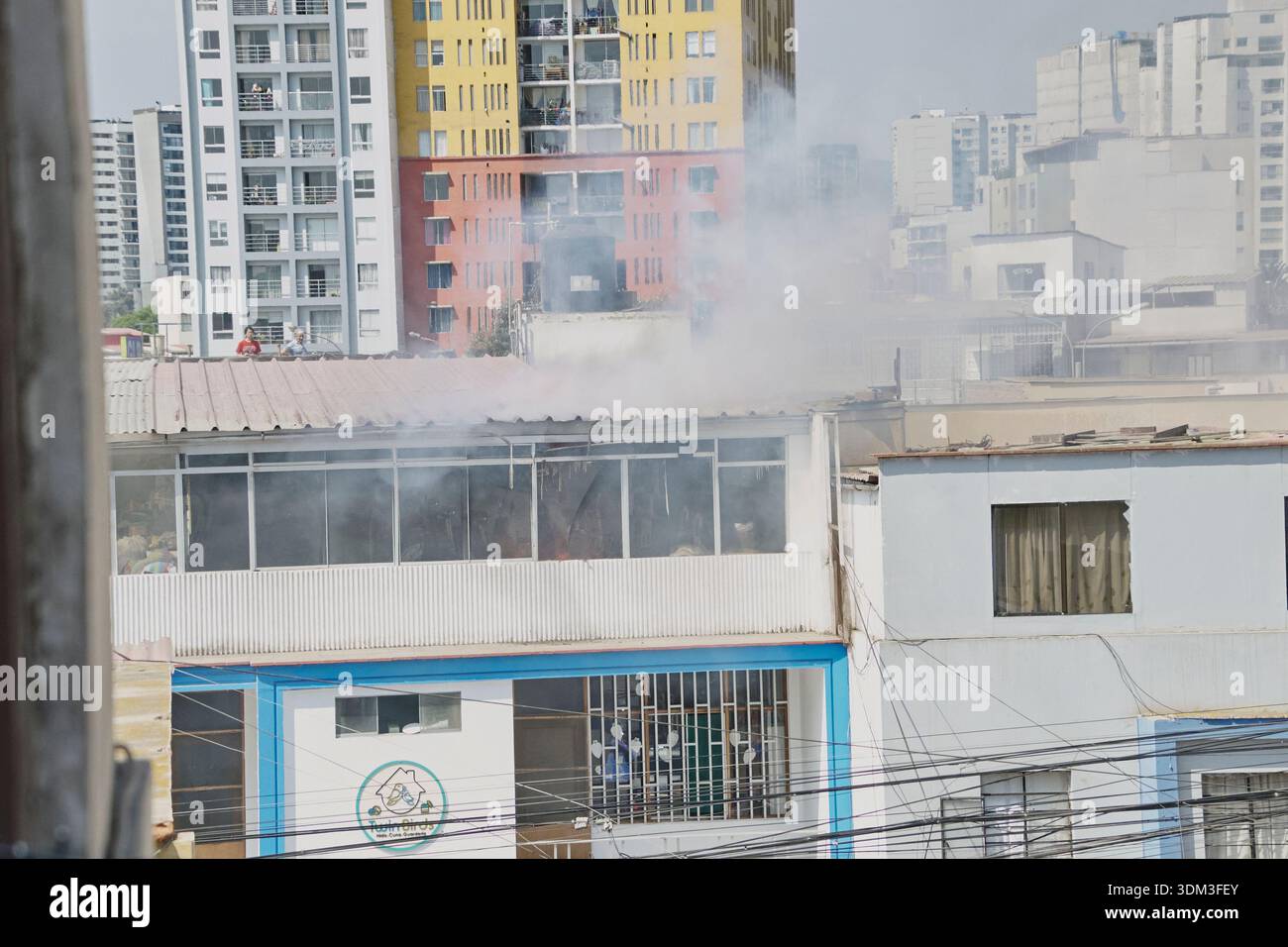 Smoke rising from a building fire in a densely populated urban area of ...