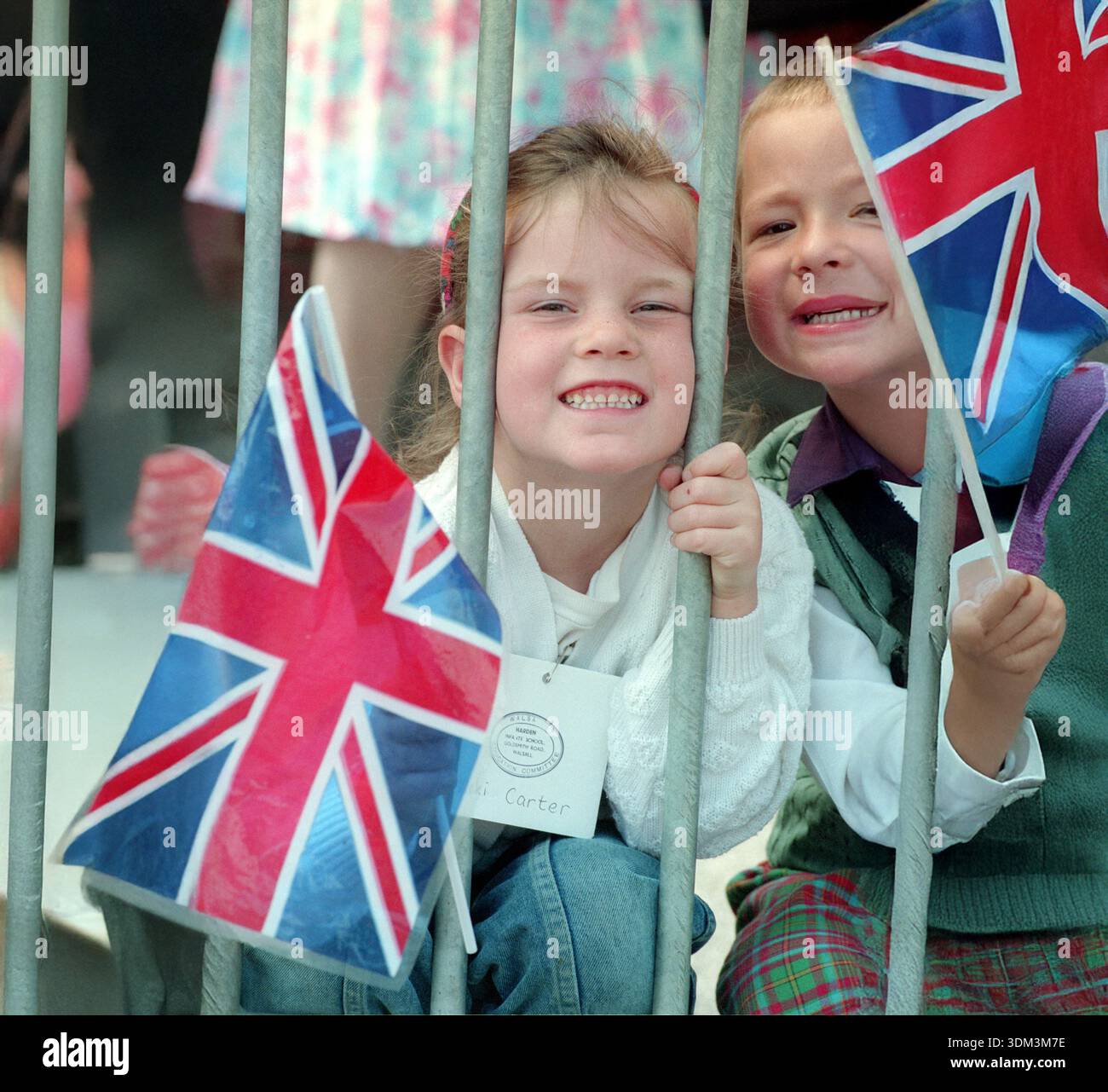 Eager to see the Queen. Children waving union flags for the visit of ...