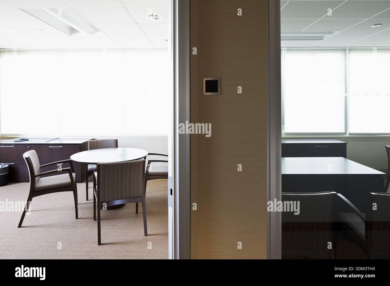 A modern, vacant office suite featuring an empty meeting table and ...