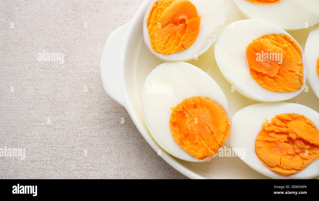 Hard boiled eggs peeled and cut in plate Stock Photo - Alamy