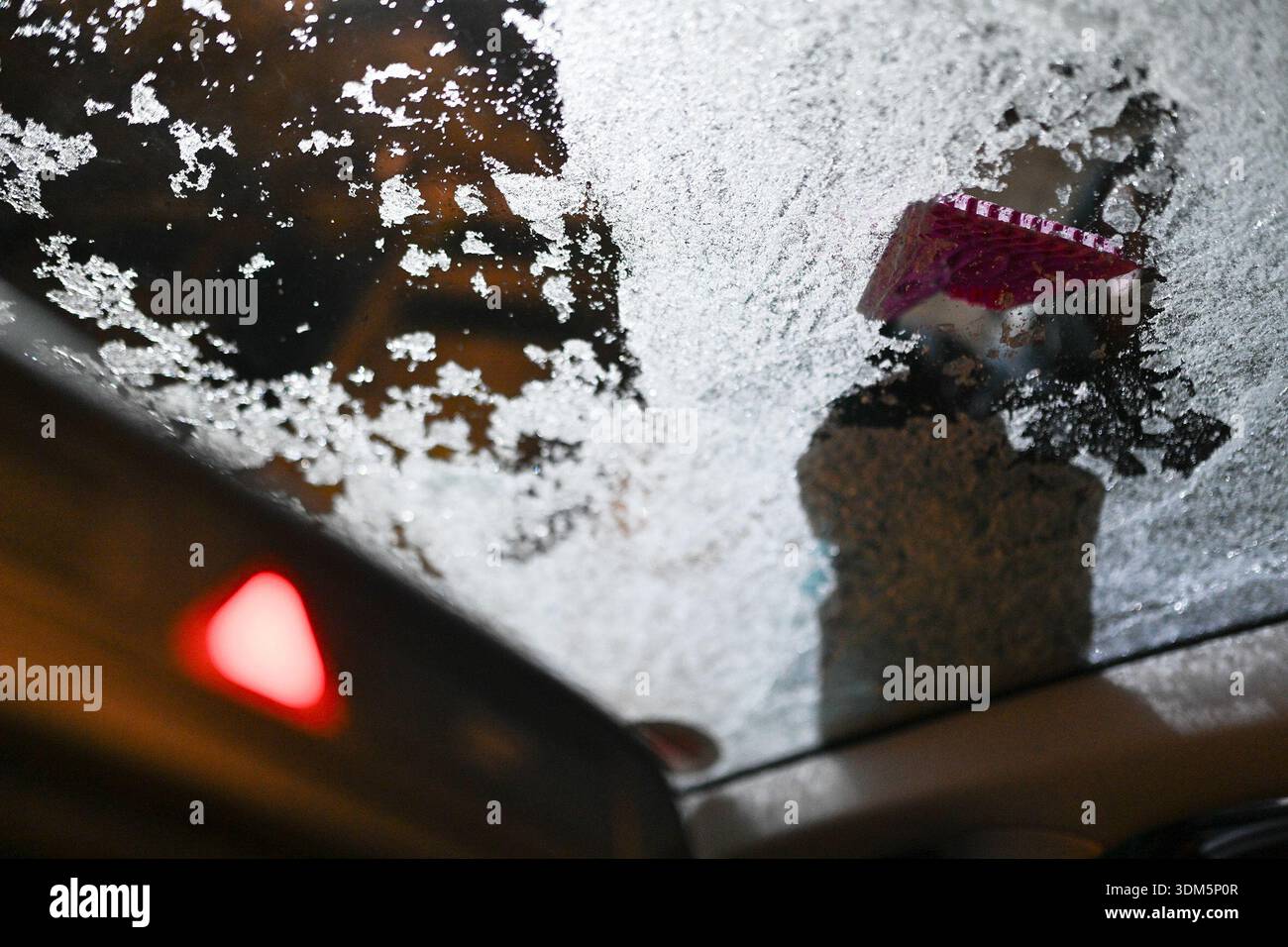 04 February 2026, Leer: A heavily iced windshield is cleared of ice ...