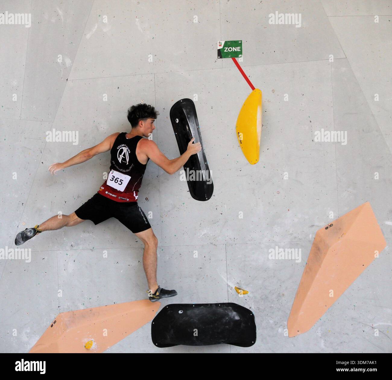 Pure strength and precision: a climber in full extension on a technical ...