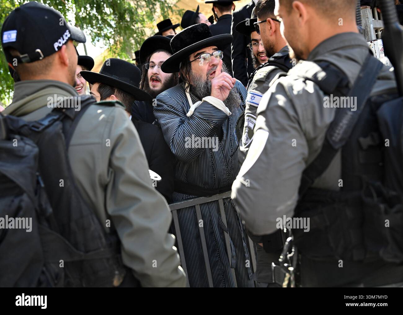 Israeli police guard Ultra-Orthodox Jews during a protest, next to the ...