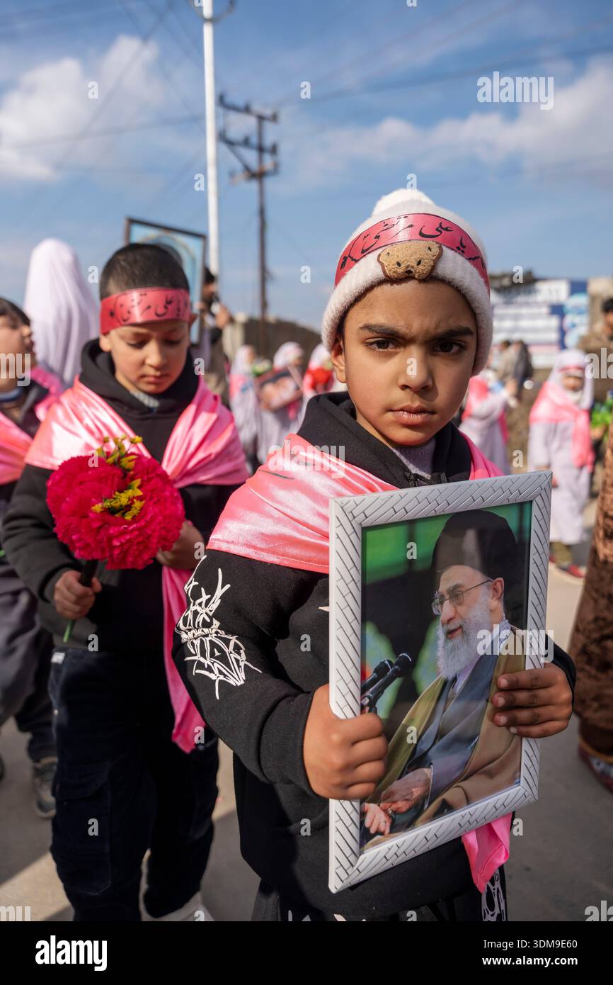 A Kashmiri Shia Muslim boy looks on as he hold a photograph of Iranian ...