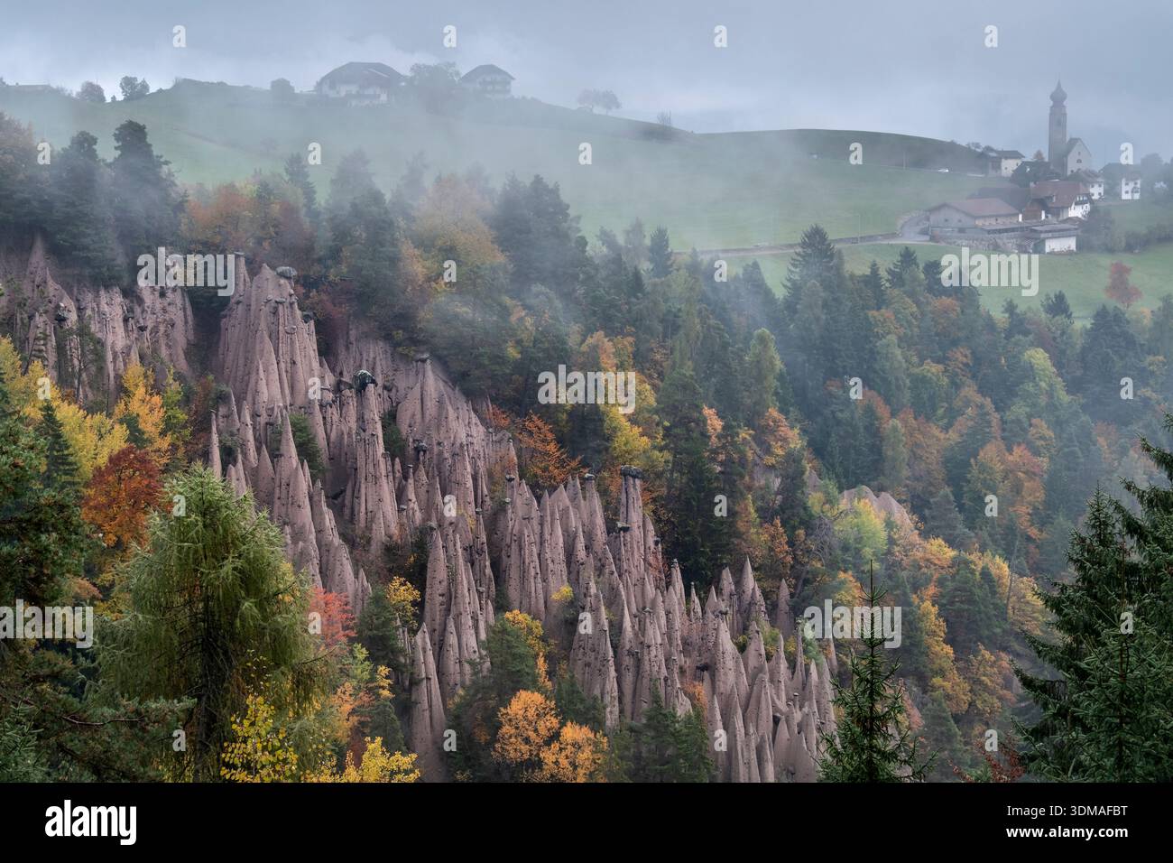 Fog clearing from the Earth Pyramids or Hoodoos of Longomoso backed by ...