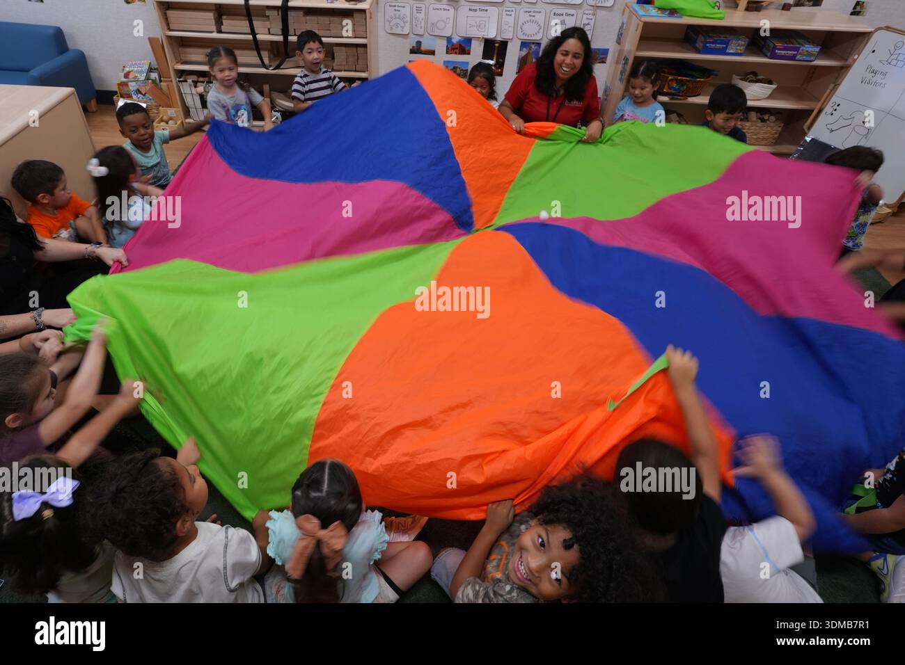 Pre-K 4 SA teacher Deziree Arce, center, plays a parachute game with ...