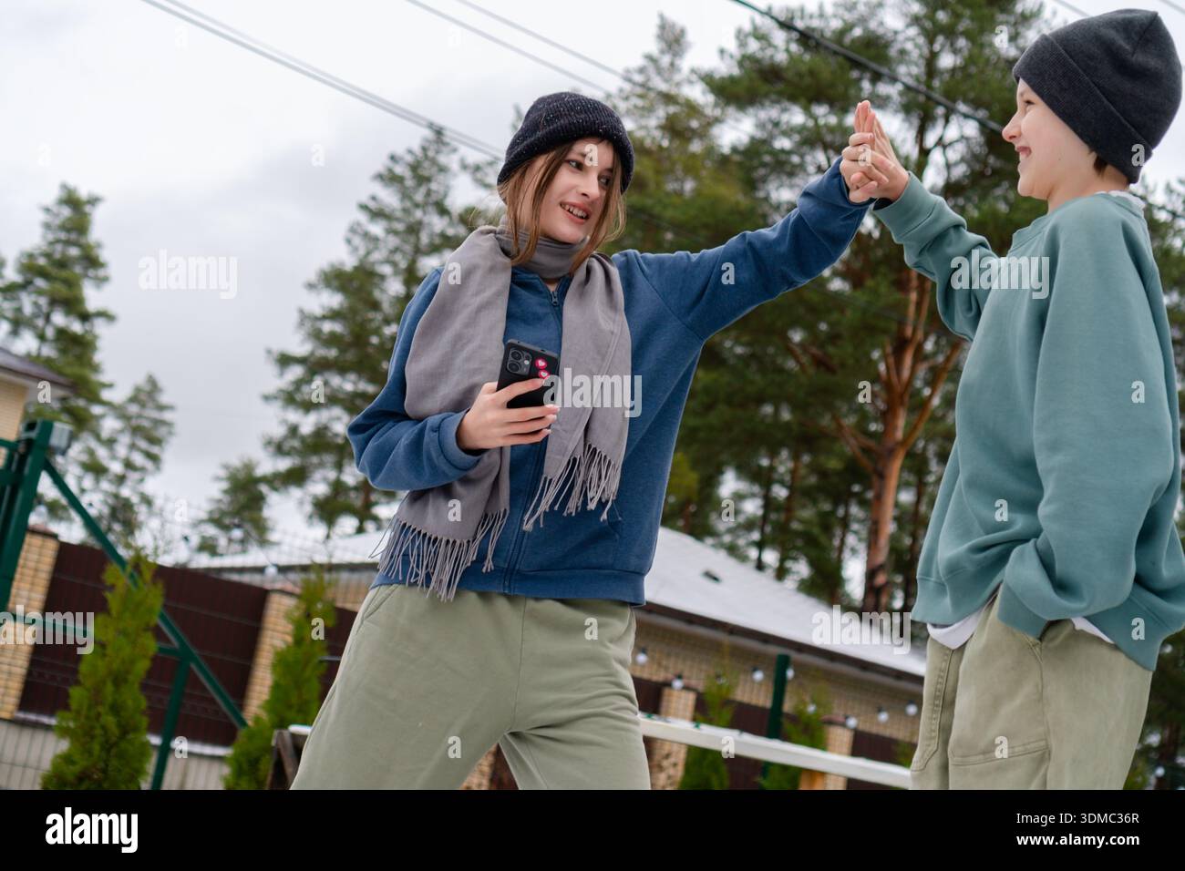 A dynamic low-angle shot from below captures a teenage brother and ...
