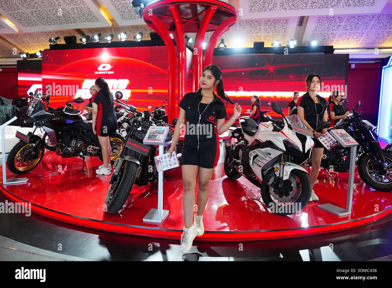 Models stand near QJMOTOR booth from Chinese Qianjiang Motorcycle Group ...