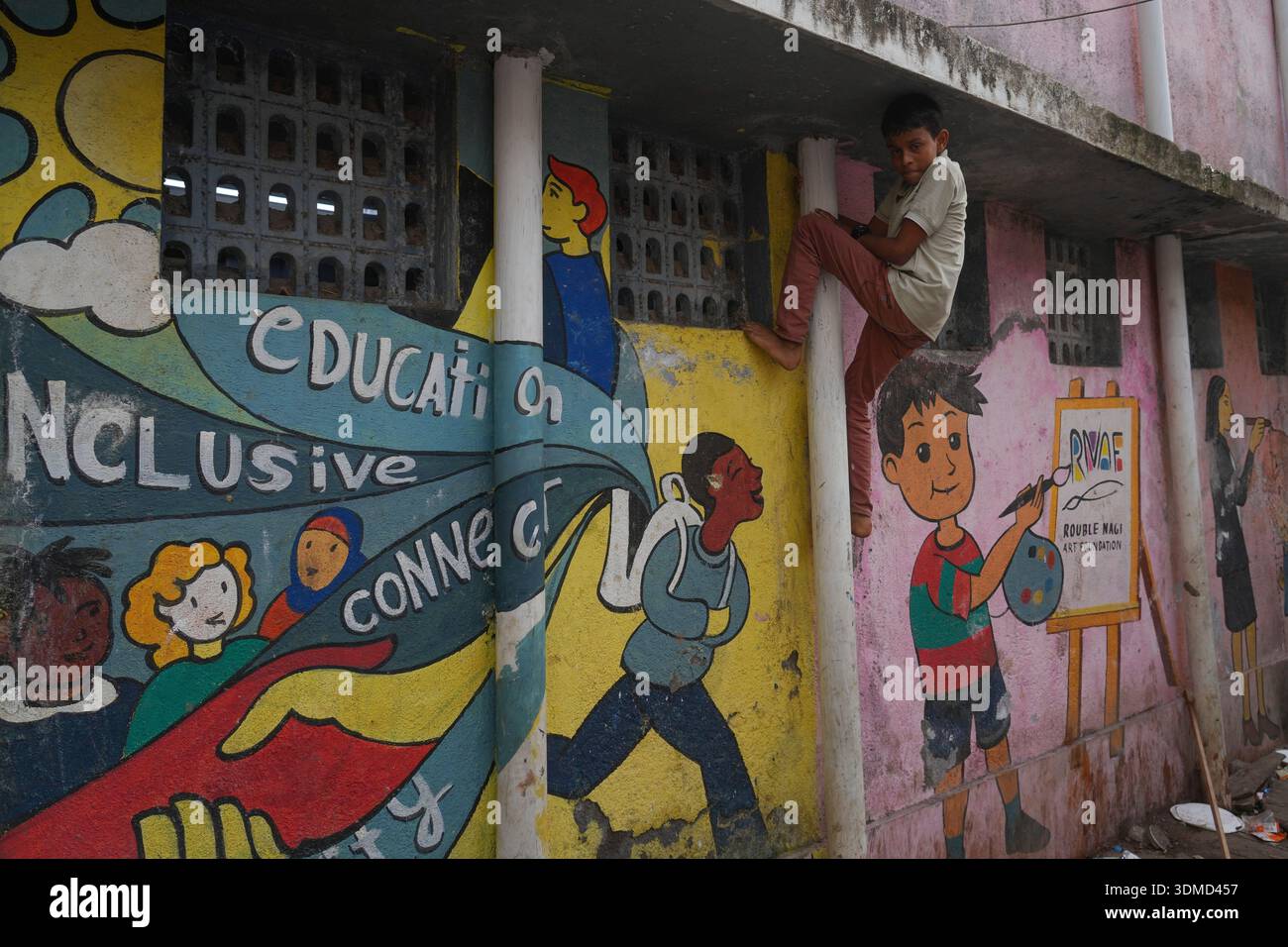 A boy climbs on a pipe next to a wall showing a mural by the Rouble ...