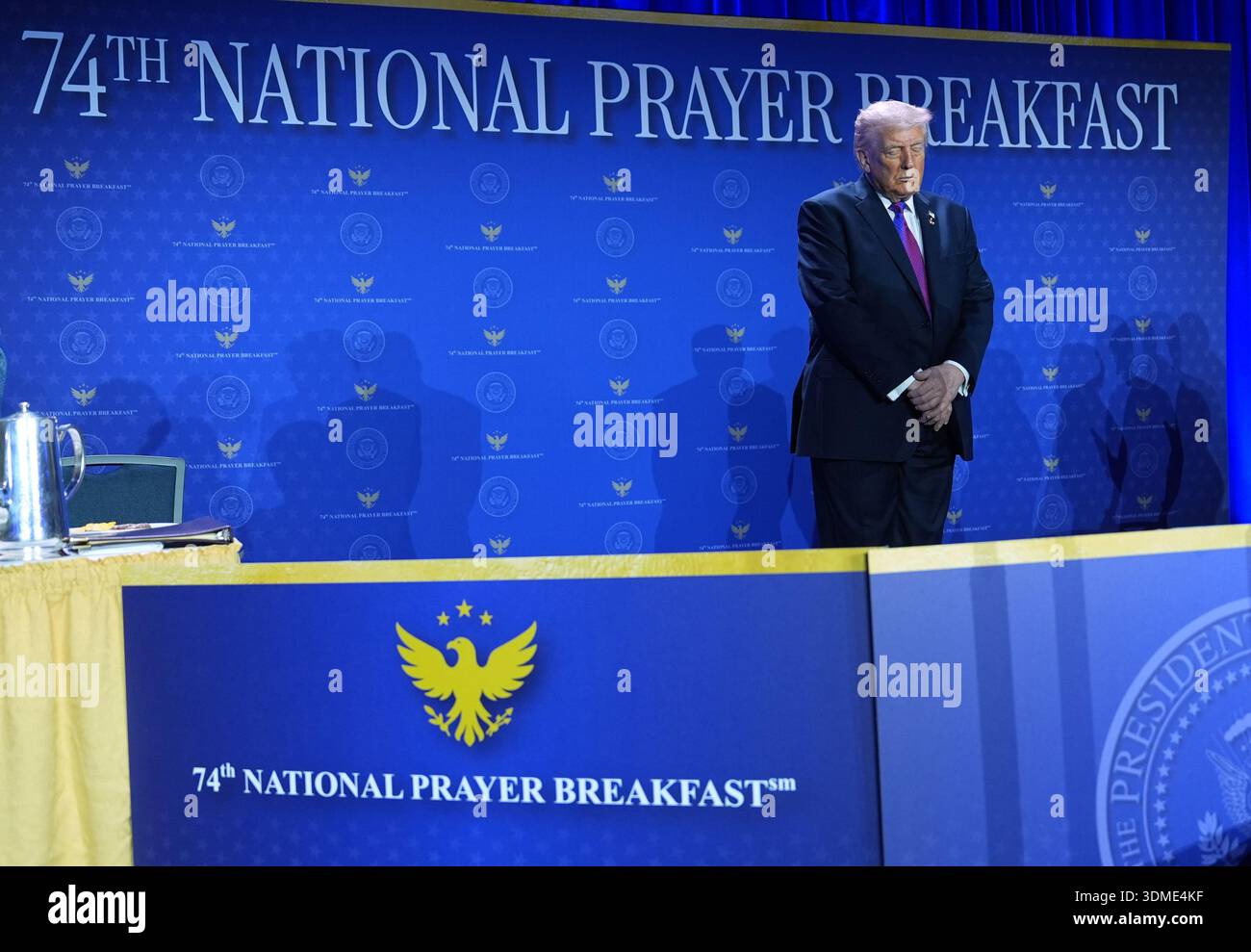 President Donald Trump bows his head during the National Prayer ...
