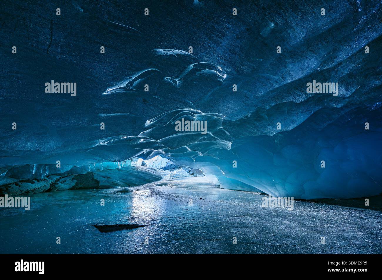 Inside of an ice cave with a person in red cloth showing the scale of ...