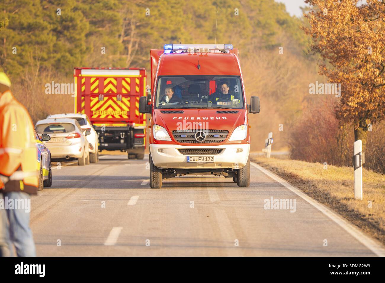 Two fire engines drive on a country road, road markings visible, fire ...
