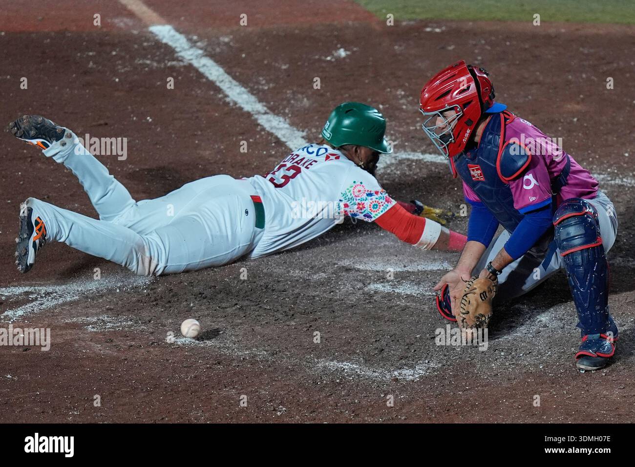 Mexico Green's Yadir Drake slides onto home plate to score a run ...