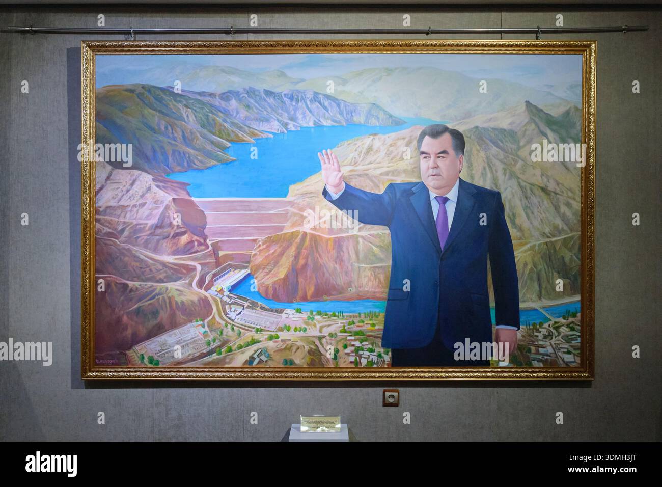 A painting of President Emomali Rahmon, waving at a dam site. At the ...