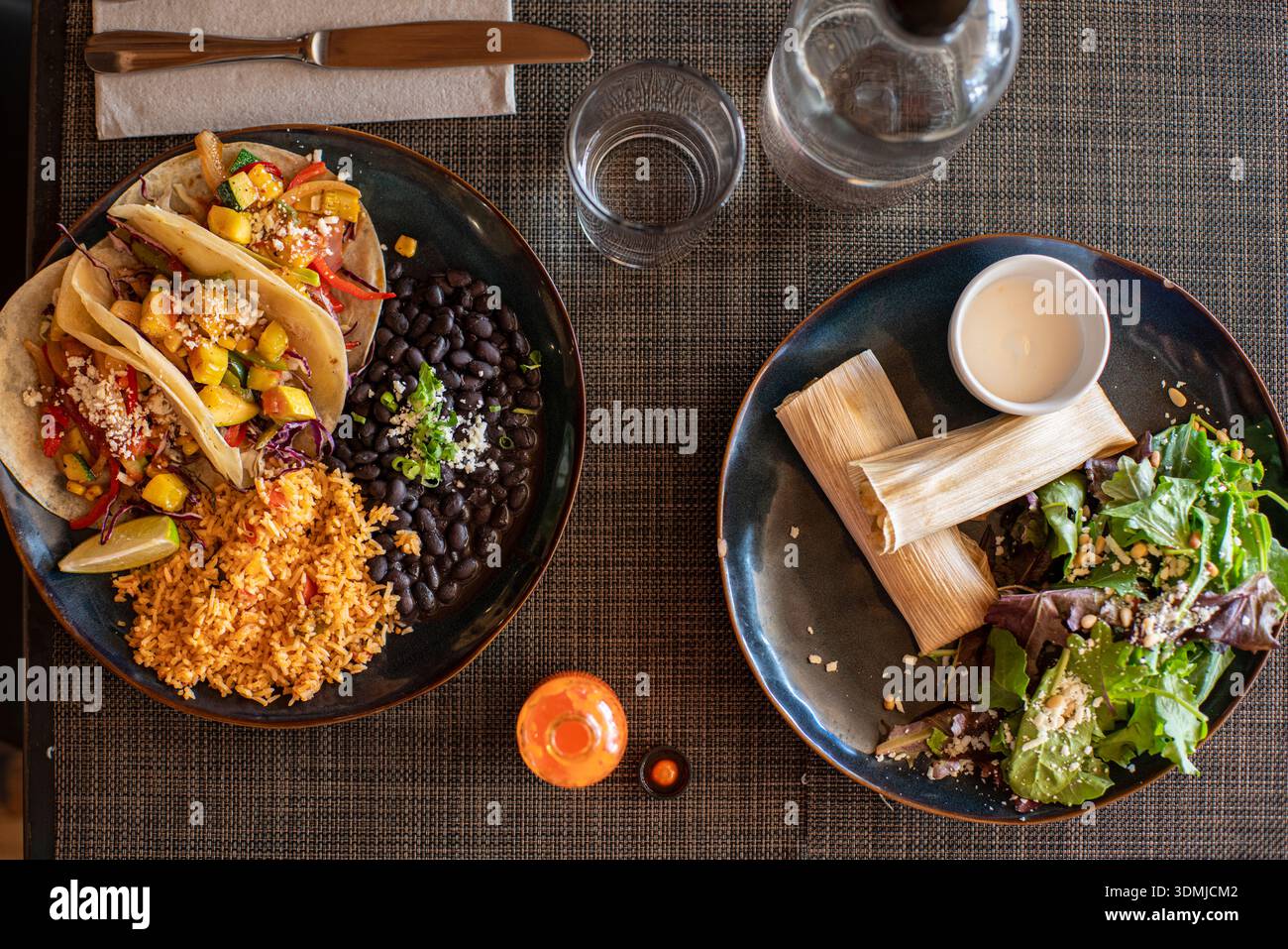 Looking down on plates of tacos and tamales in restaurant Stock Photo ...