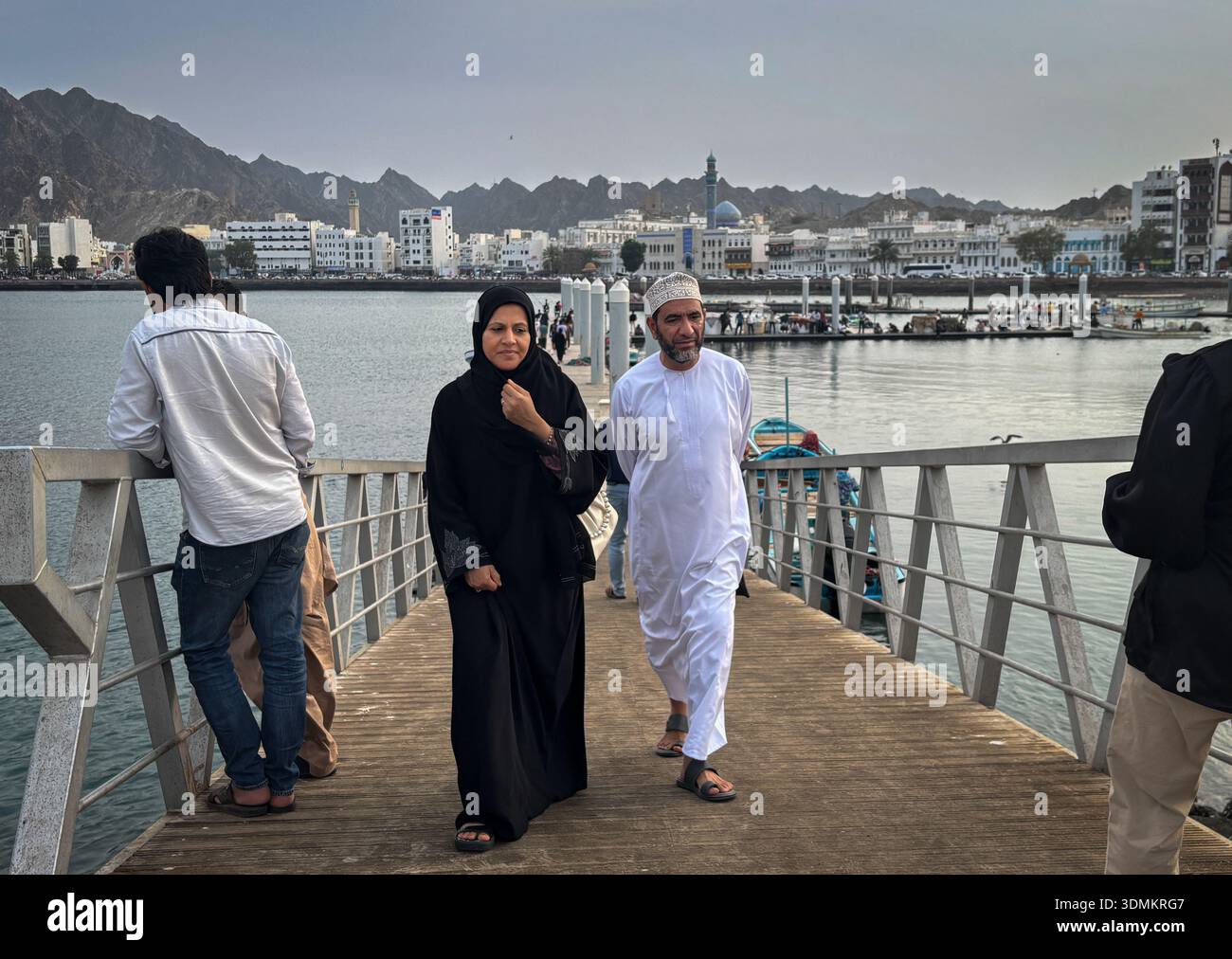 An Omani couple walks on a pier near the Mutrah Corniche in Muscat ...