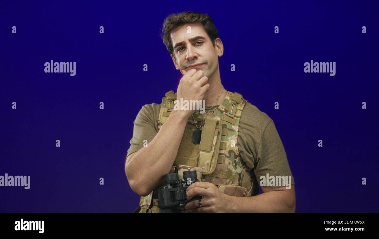 Man soldier standing holding binoculars and dog tags with hand on chin ...