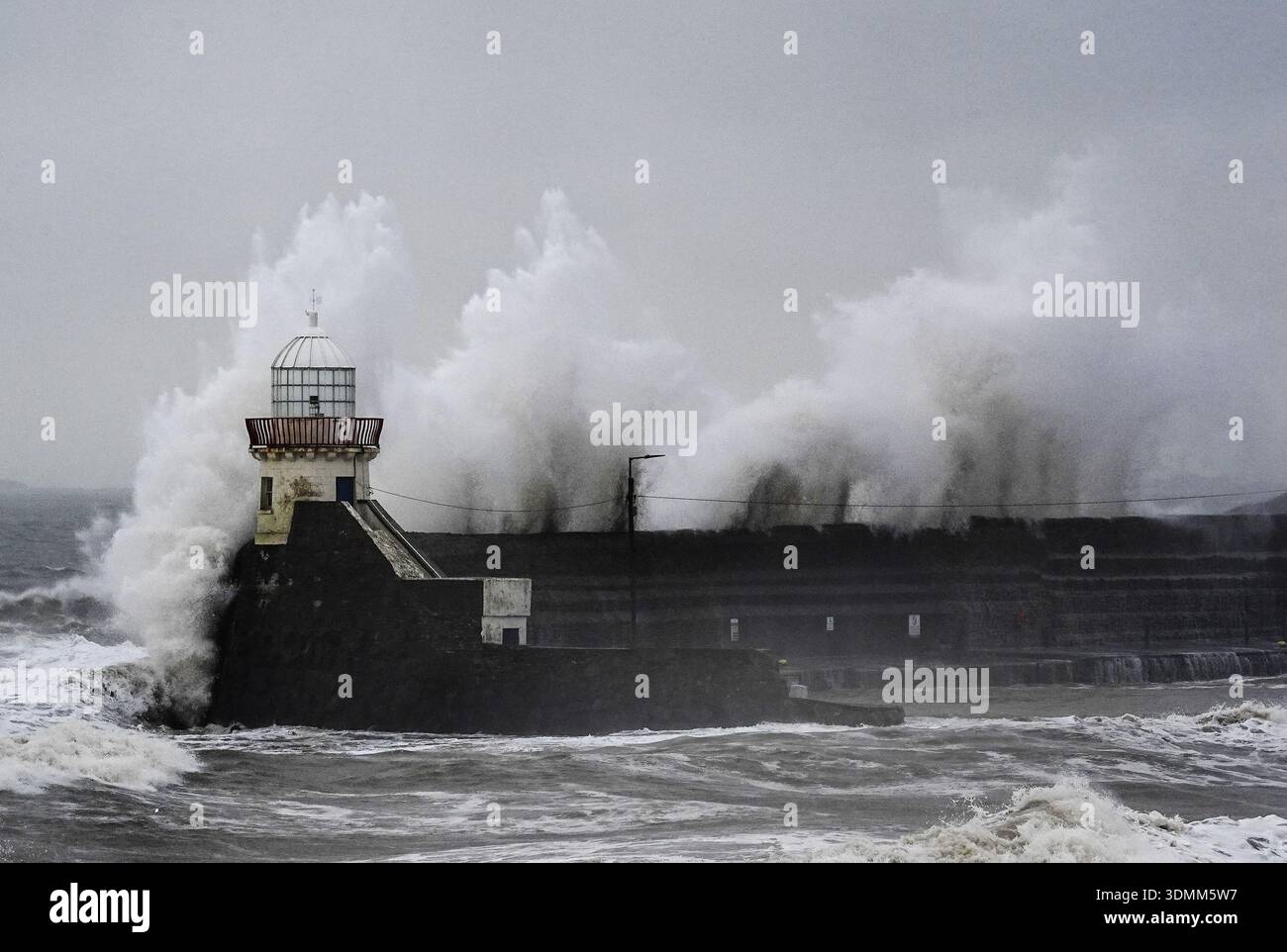 Waves crash against Balbriggan lighthouse in Co. Dublin. Parts of ...