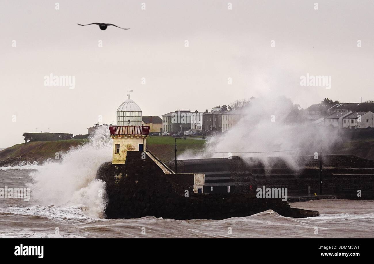Waves crash against Balbriggan lighthouse in Co. Dublin. Parts of ...