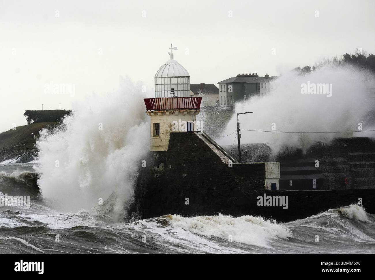 Waves crash against Balbriggan lighthouse in Co. Dublin. Parts of ...