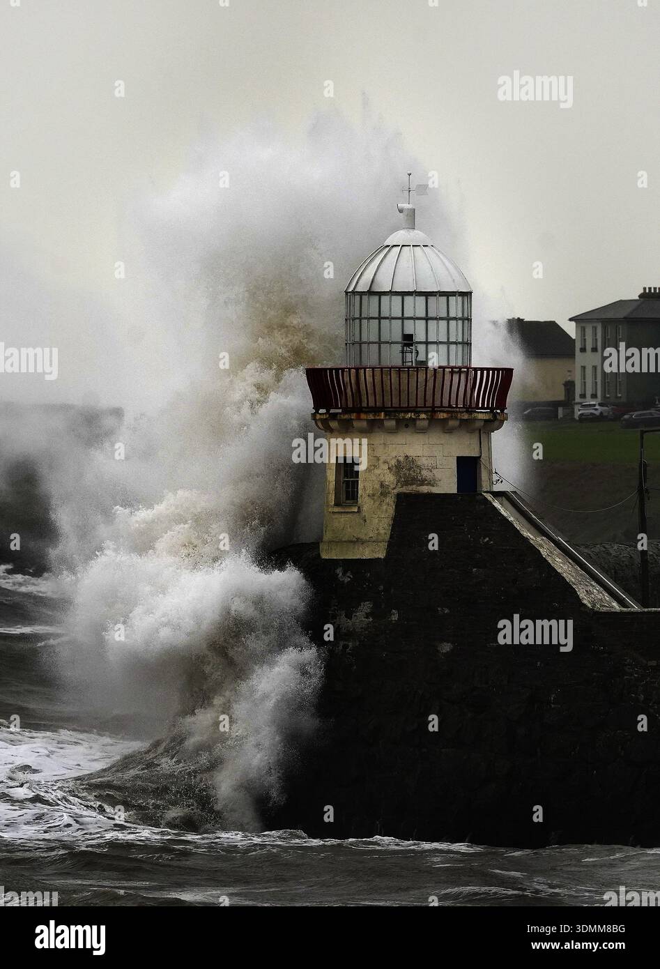 Waves crash against Balbriggan lighthouse in Co. Dublin. Parts of ...