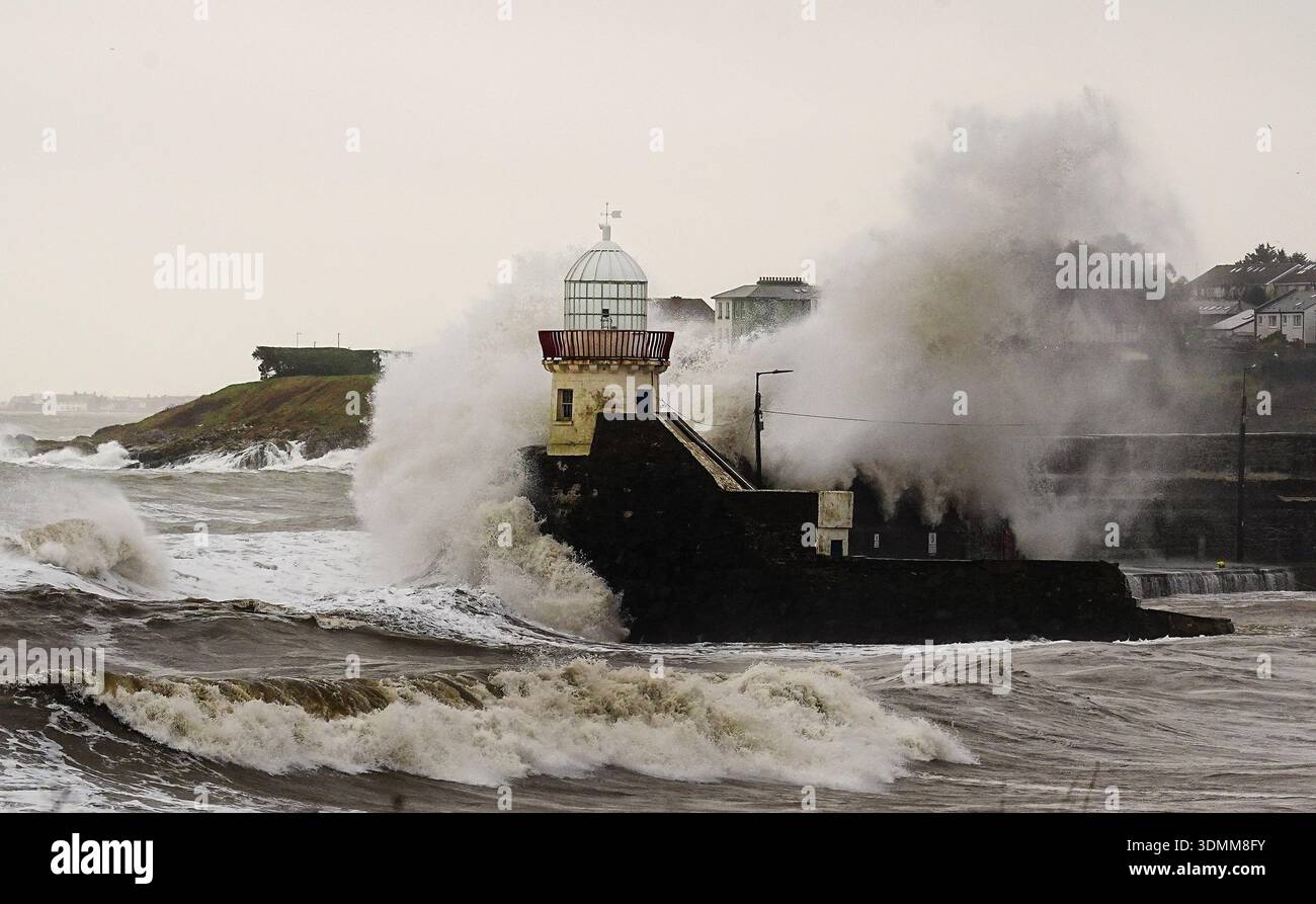 Waves crash against Balbriggan lighthouse in Co. Dublin. Parts of ...