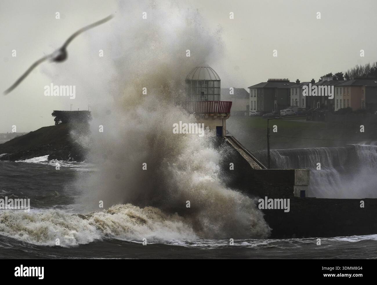 Waves crash against Balbriggan lighthouse in Co. Dublin. Parts of ...
