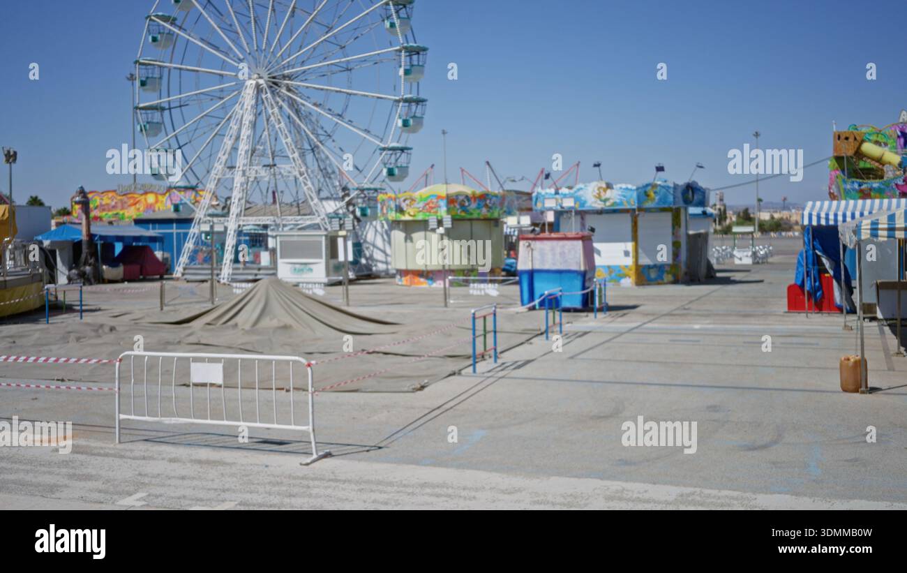 Fairground ferris wheel, closed stalls and empty walkways in soft ...