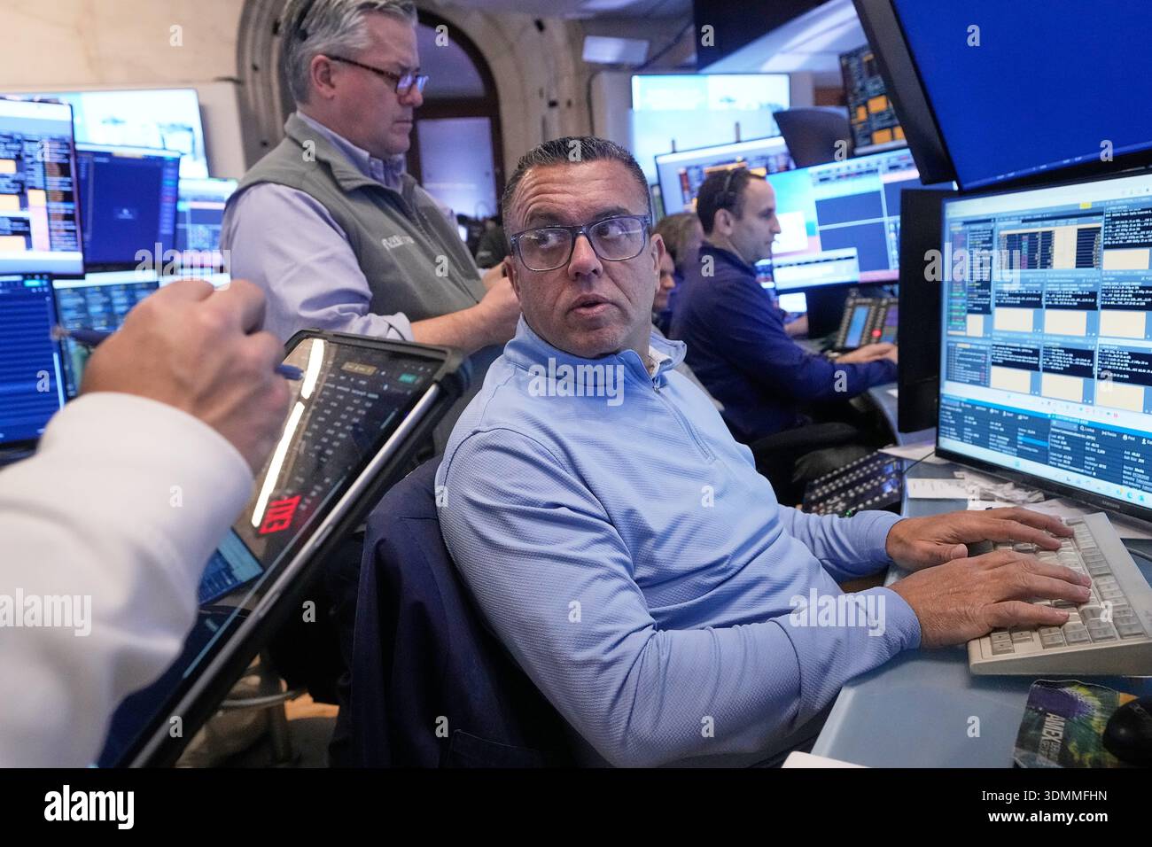 Trader Robert Finnerty Jr., seated center, works with colleagues on the ...