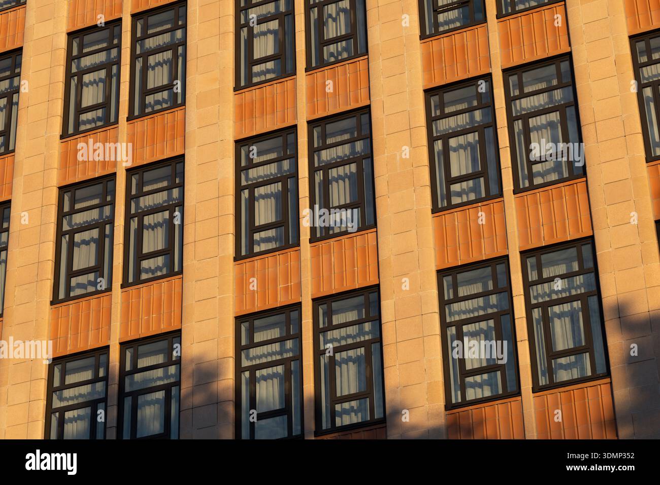 Facade detail of a mid-century office building with repeating windows ...